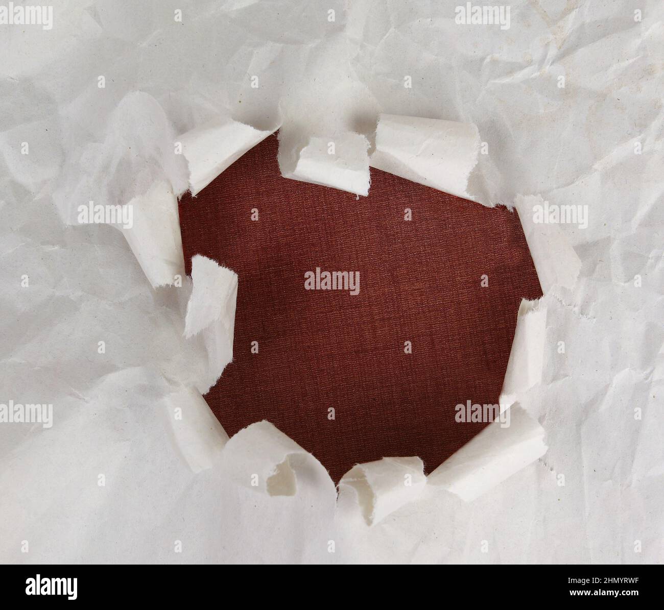 Hole in the paper with torn Stock Photo - Alamy