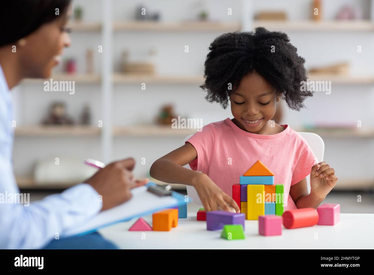 Child development specialist observing cheerful child preschooler Stock ...