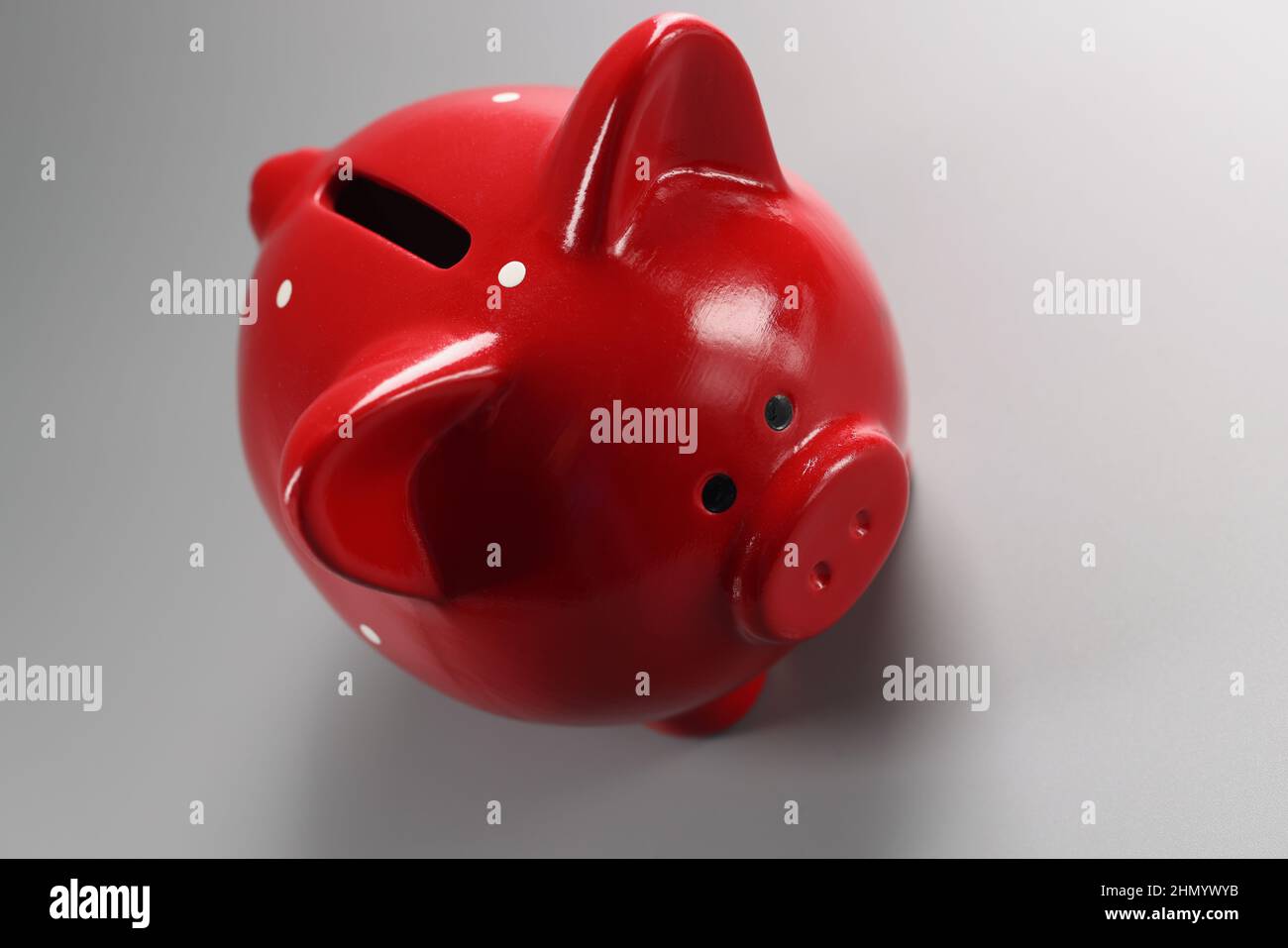 Red piggybank container on grey surface with hole for coins, empty ...