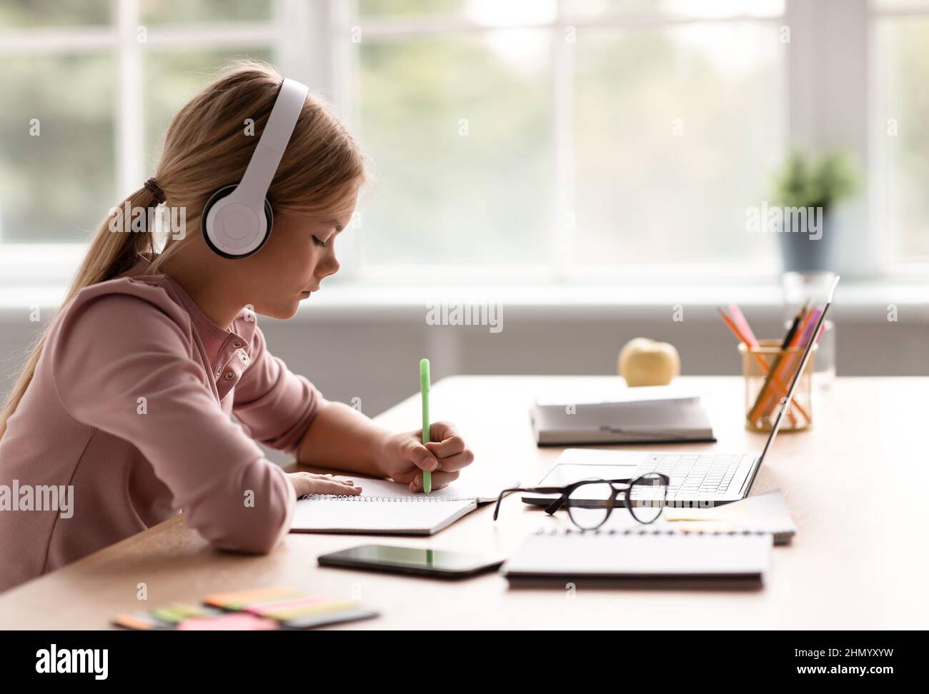Busy serious european teen blonde girl student learning by laptop with ...