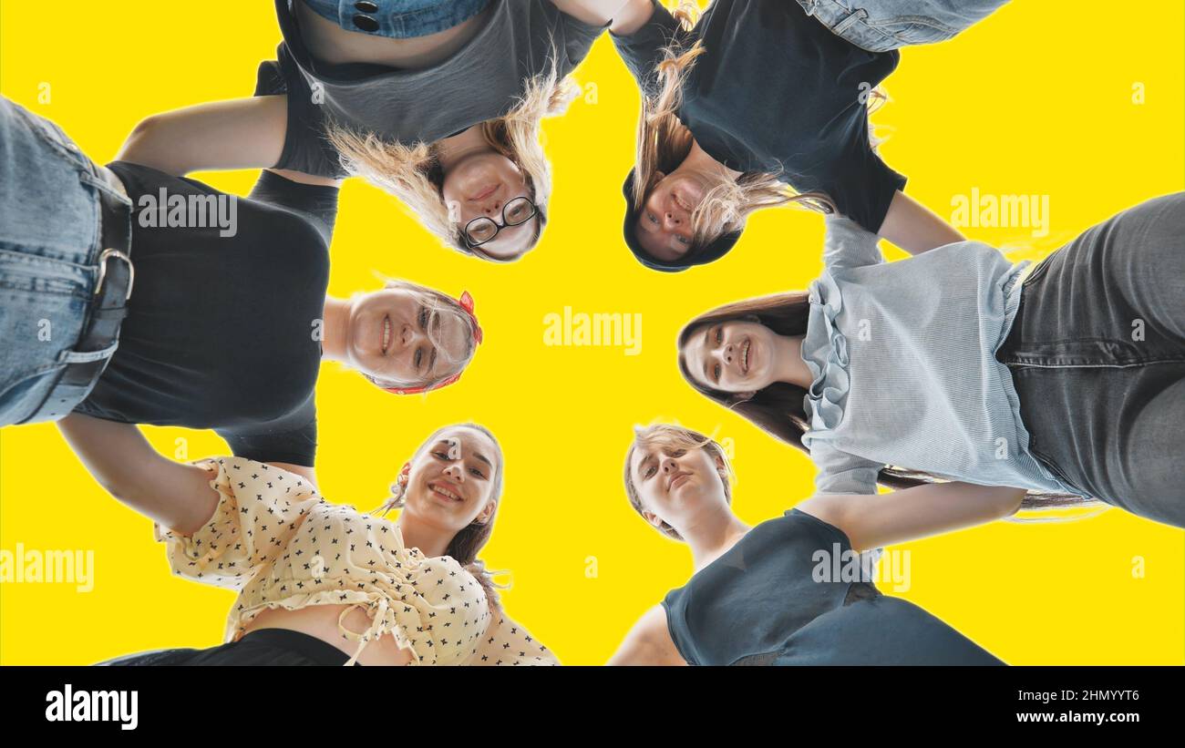Happy girls friends hugging in a circle on a yellow background Stock ...