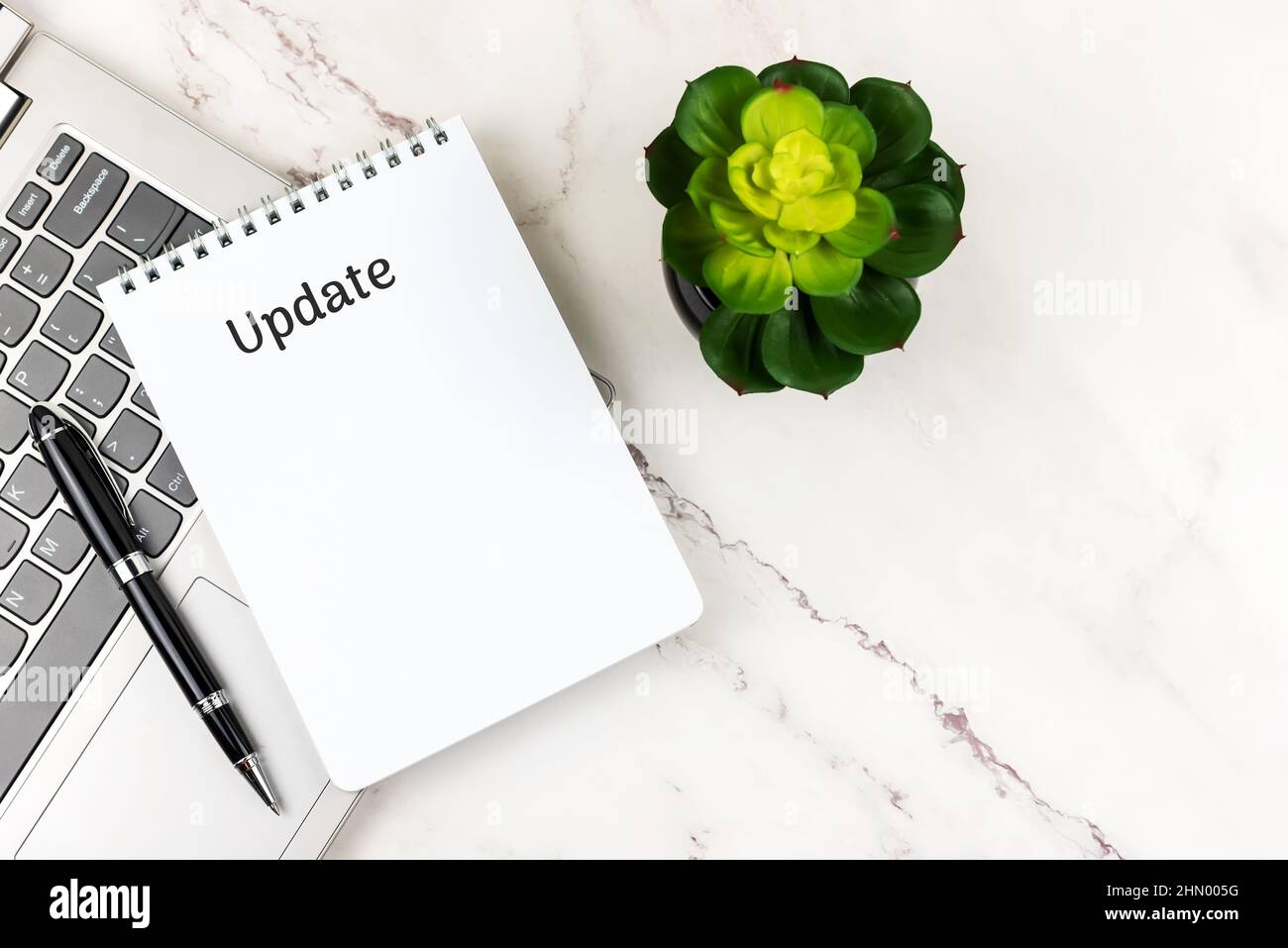 Update text on notepad with laptop and potted plant Stock Photo - Alamy