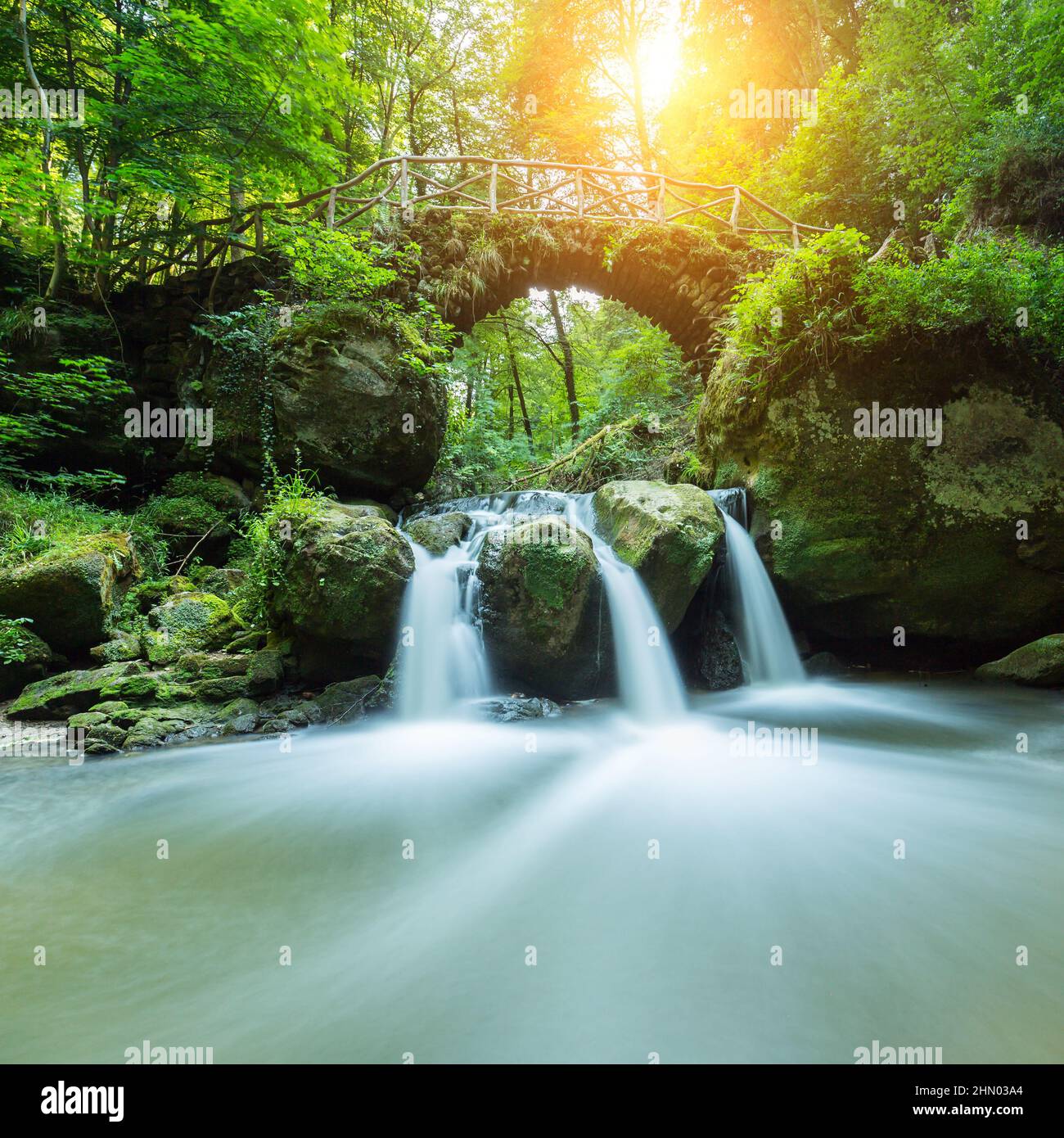 Bridge over a fairy tale waterfall Stock Photo - Alamy