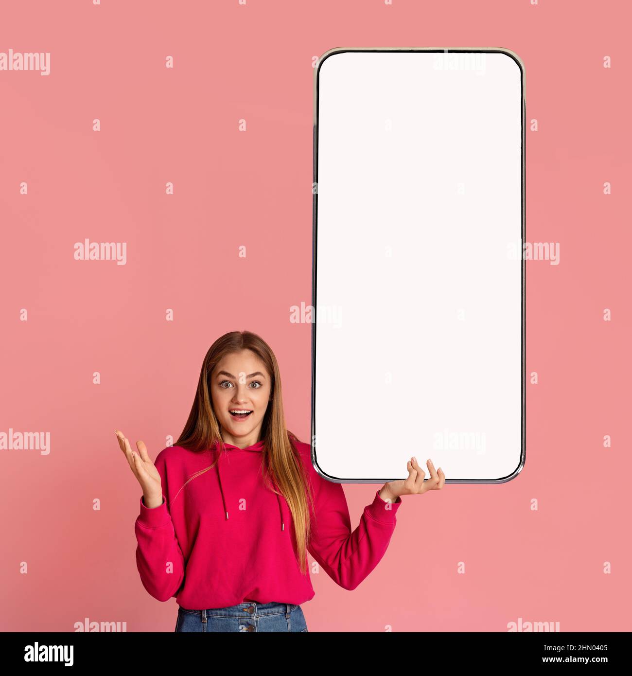 Check out this new mobile app. Excited woman presenting smartphone with ...