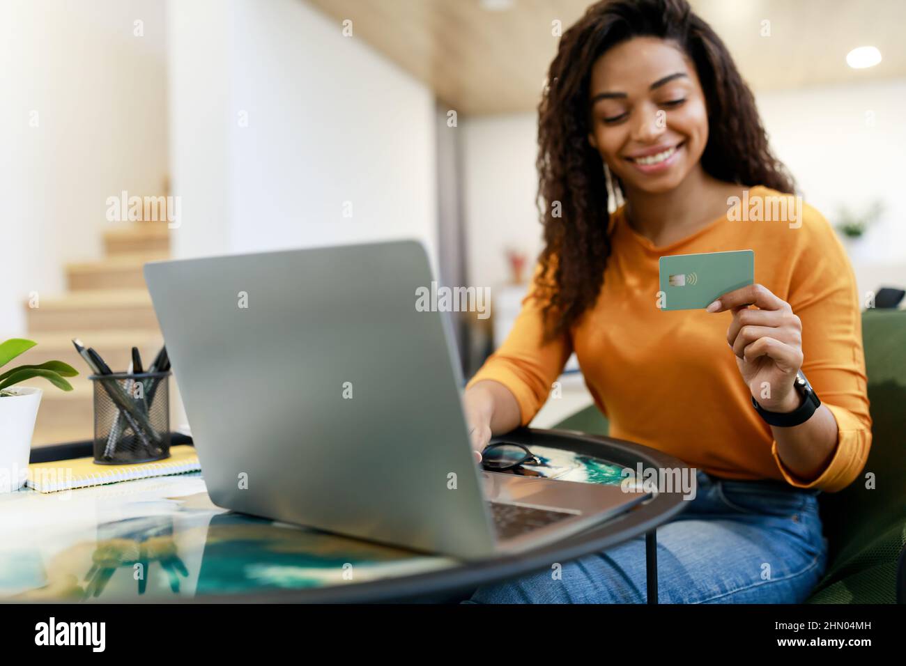 Happy woman holding debit credit card, using pc Stock Photo - Alamy