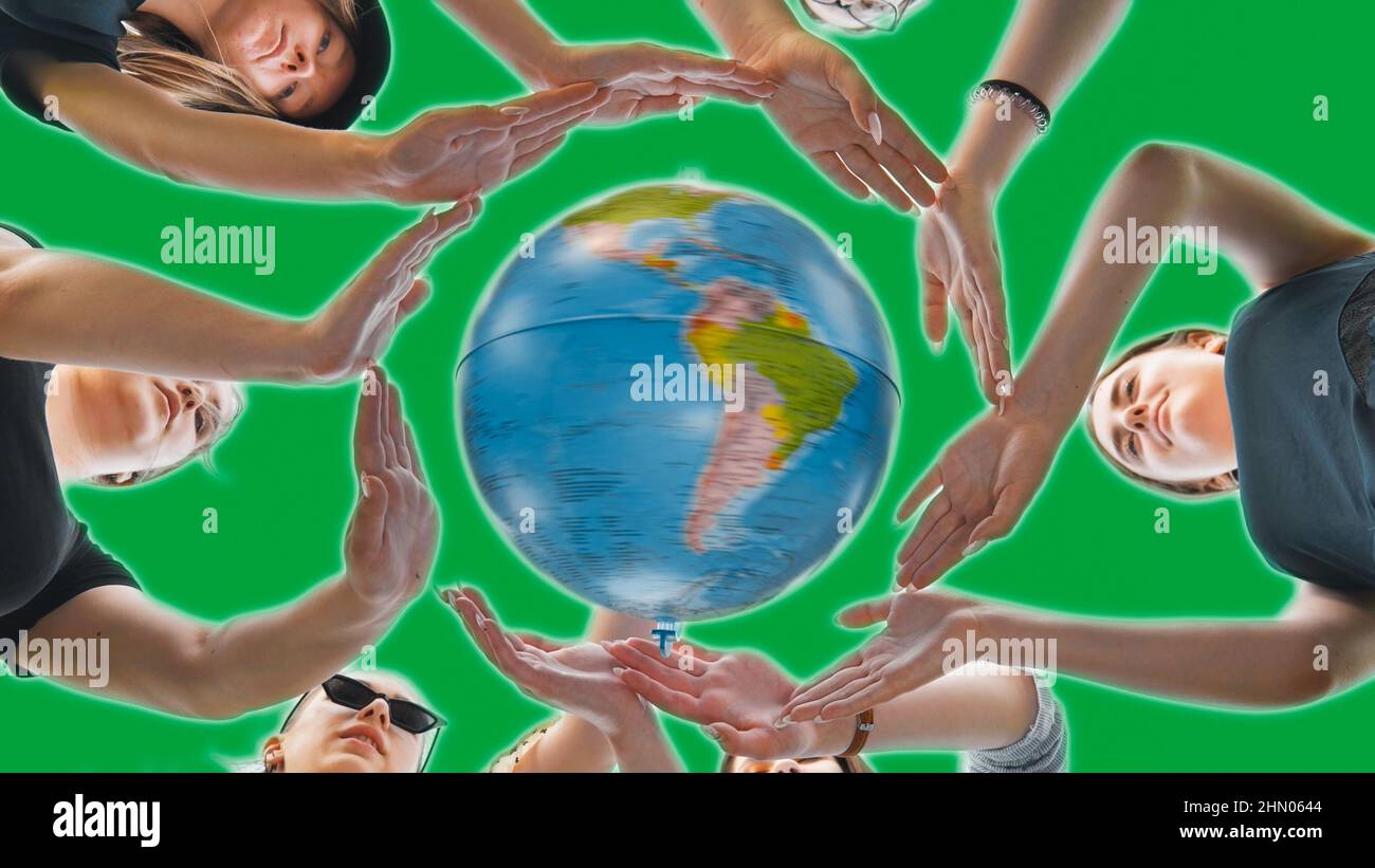 Schoolgirls hug the earth globe with their hands, making a circle out ...