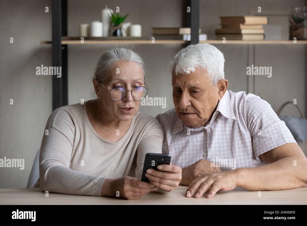 Focused old grandparents couple sharing mobile phone Stock Photo - Alamy