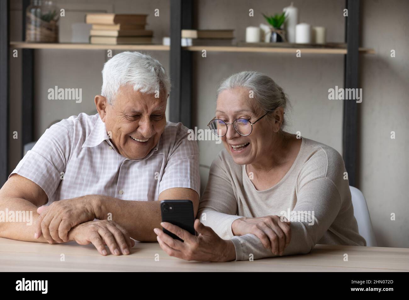 Cheerful happy older married couple using smartphone for video call ...