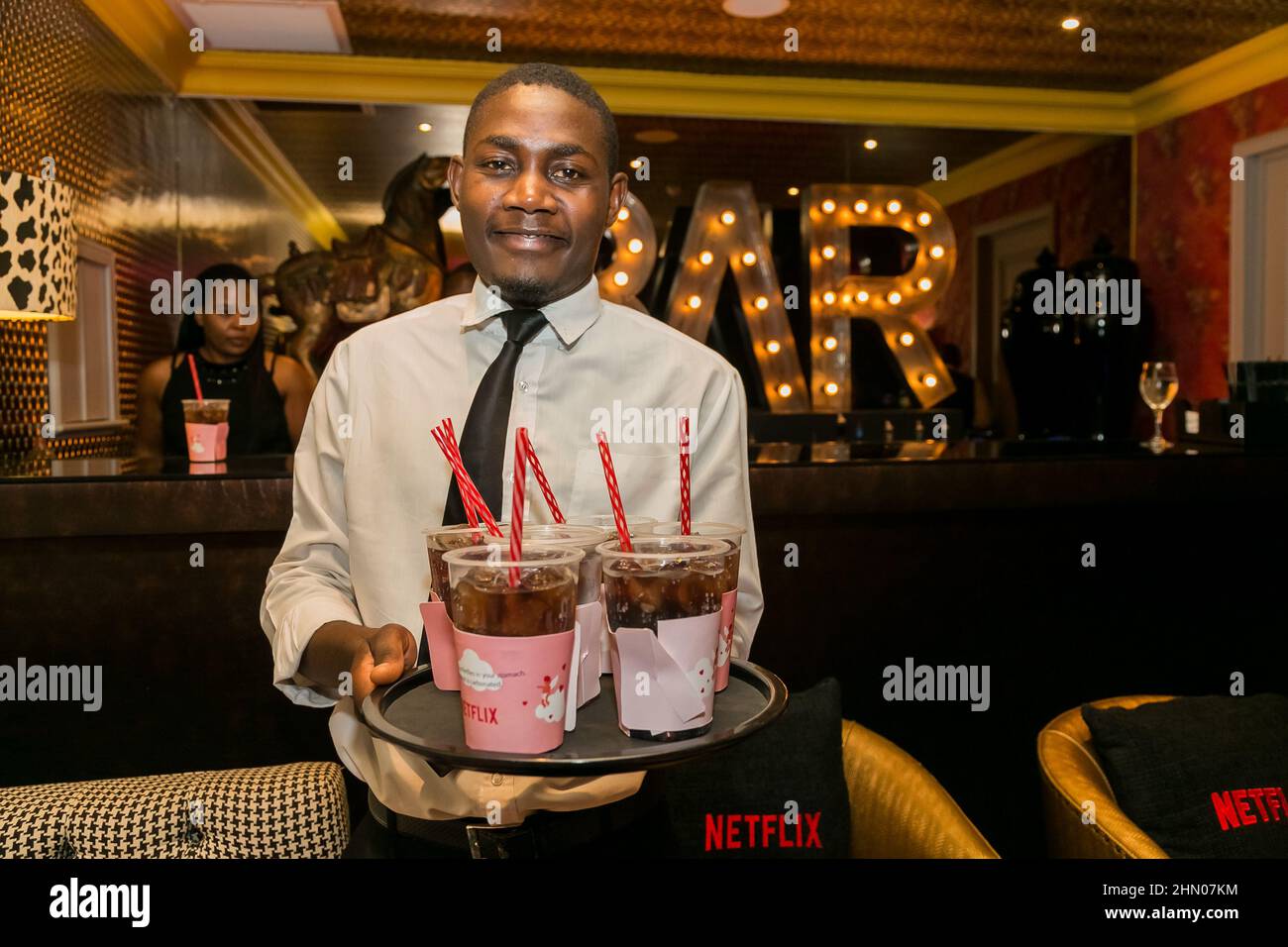 African waitering staff with welcoming drinks on a tray at a cocktail ...