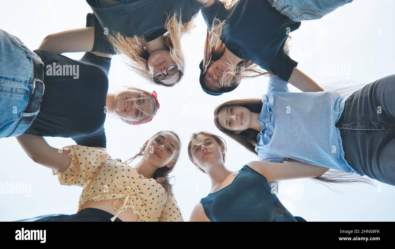 Happy girls friends hugging in a circle against the blue sky Stock ...