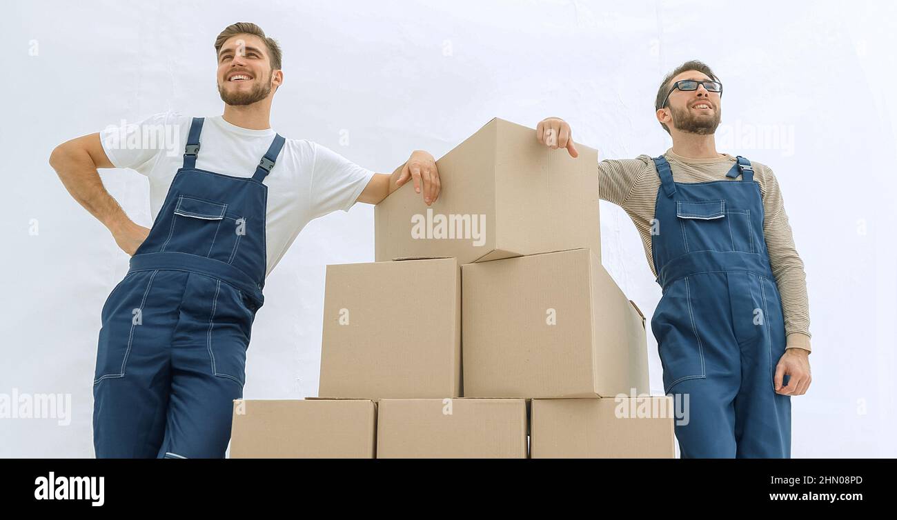 Young men carrying a box to the pile of boxes Stock Photo - Alamy