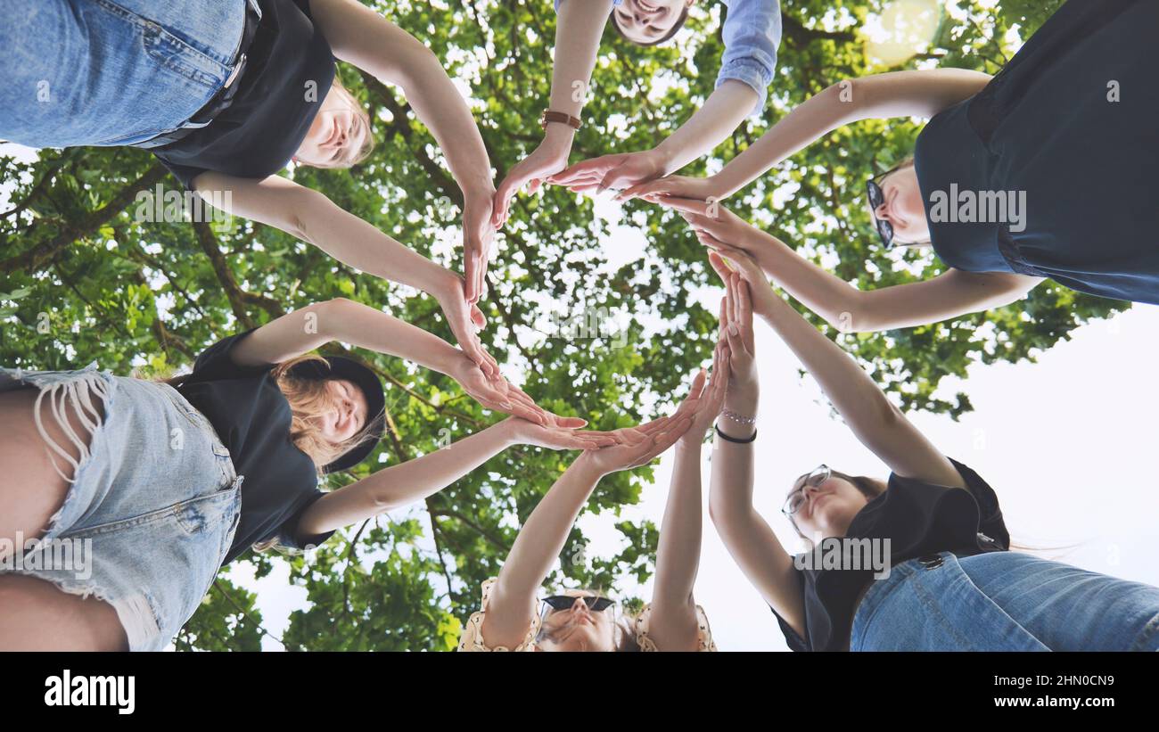 The girlfriends join their palms in a circle against the background of ...