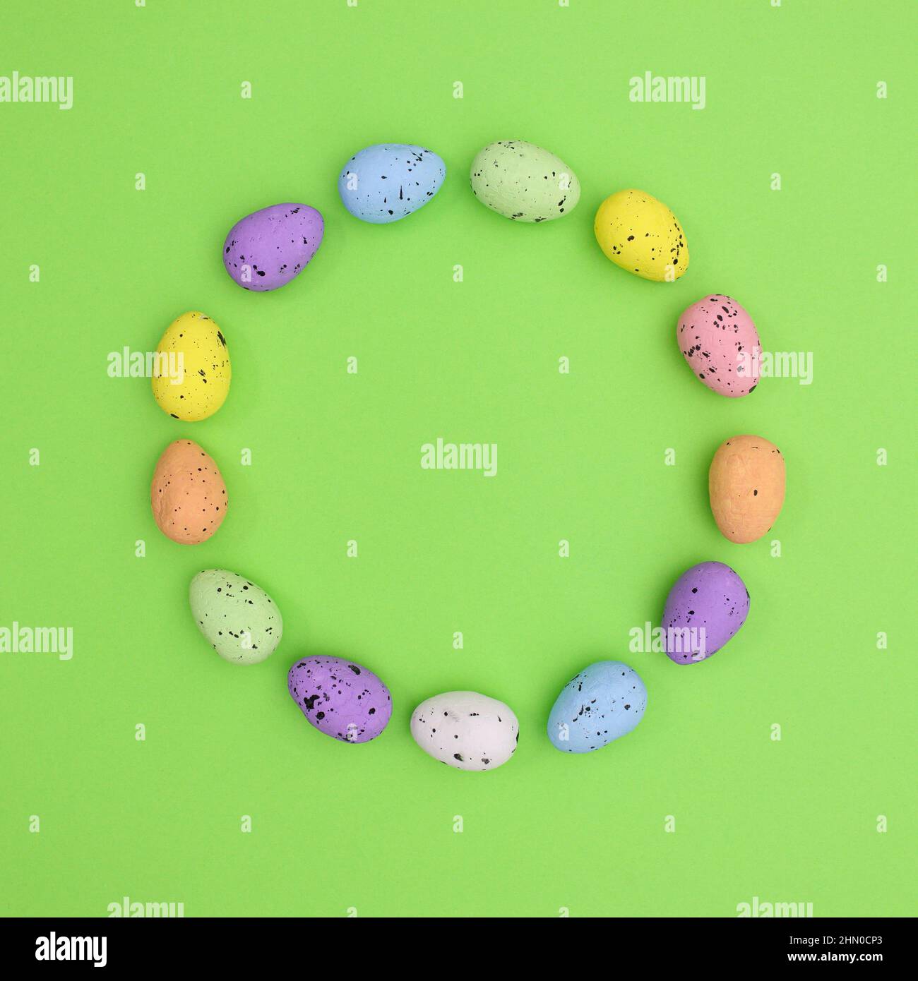 Easter circle frame with colorful rainbow eggs on bright green ...