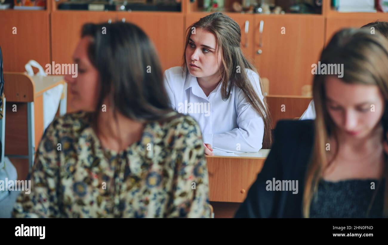 Pupils of the 11th grade in the class at the desks during the lesson ...