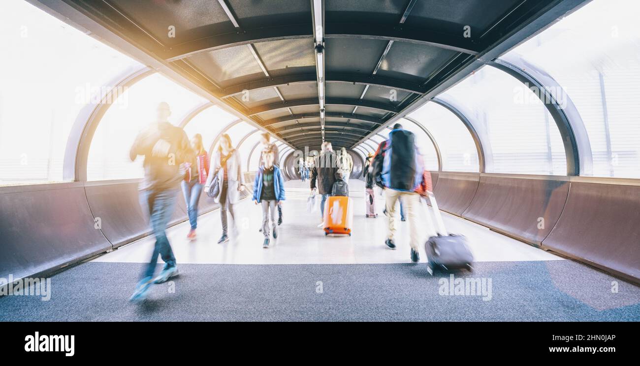 crowd of commuters rushing through an escalator in airport terminal ...