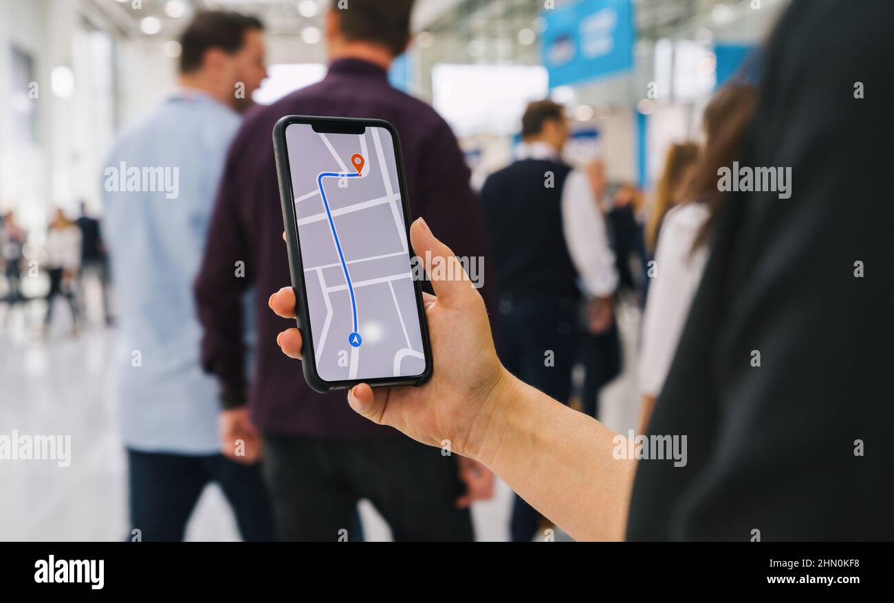Visitor using GPS map navigation app on smartphone screen to get ...