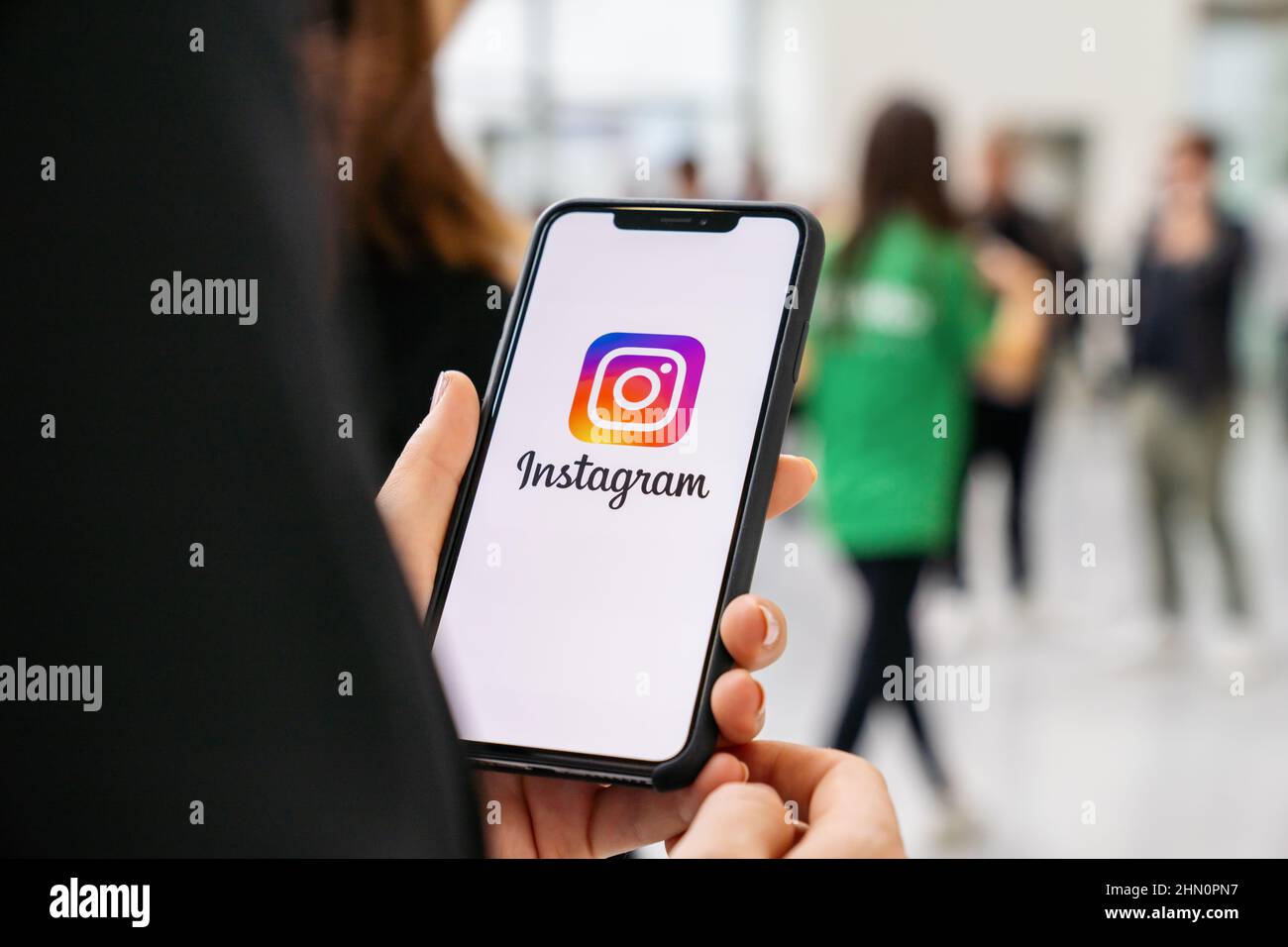 Woman hand holding iphone Xs with logo of instagram application in a ...