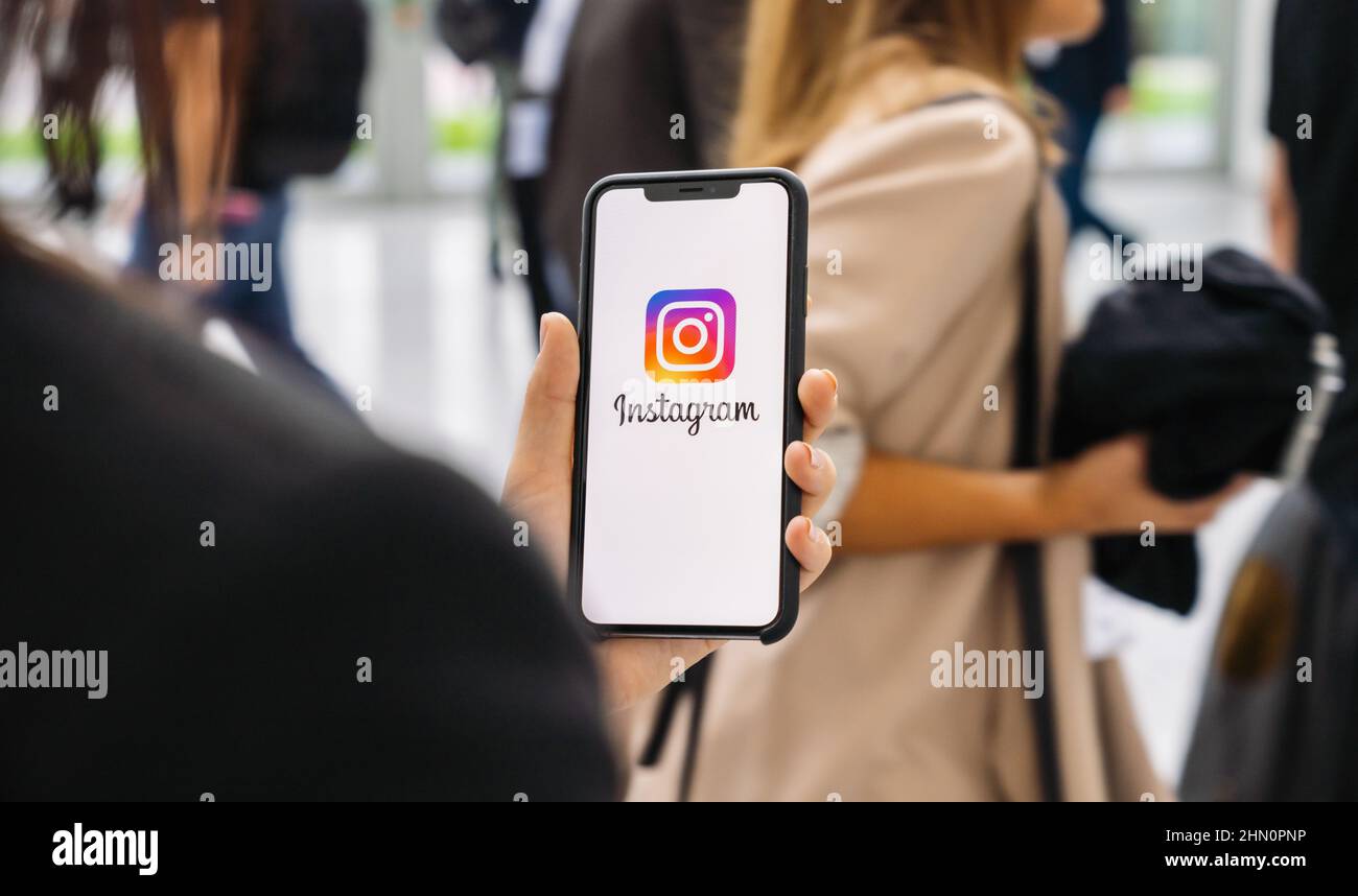 Woman hand holding iphone Xs with logo of instagram application in a ...