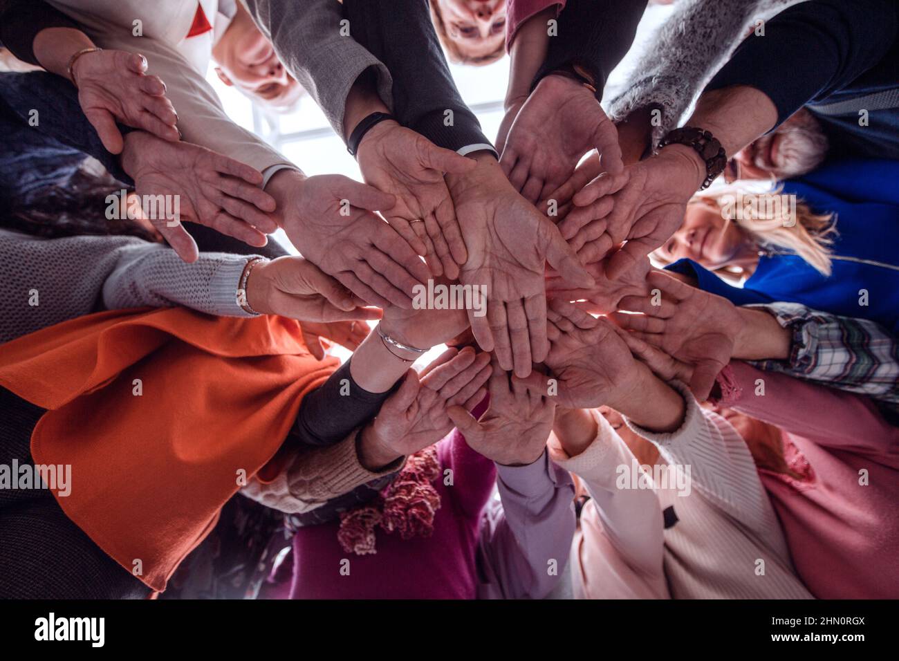 Happy people putting hands together Stock Photo - Alamy