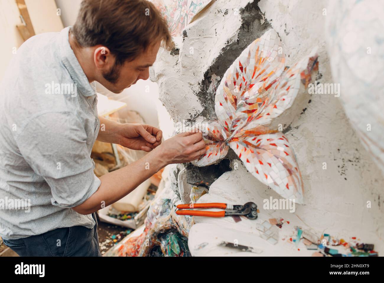 Workplace mosaics master making smalt glass mosaic panel. Man mosaicist ...