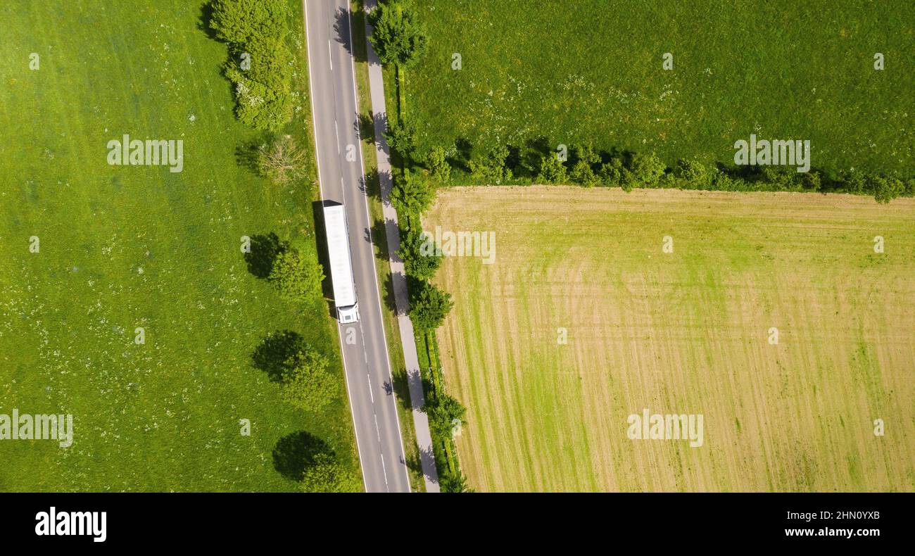 Aerial view of two lane road through countryside and cultivated fields ...