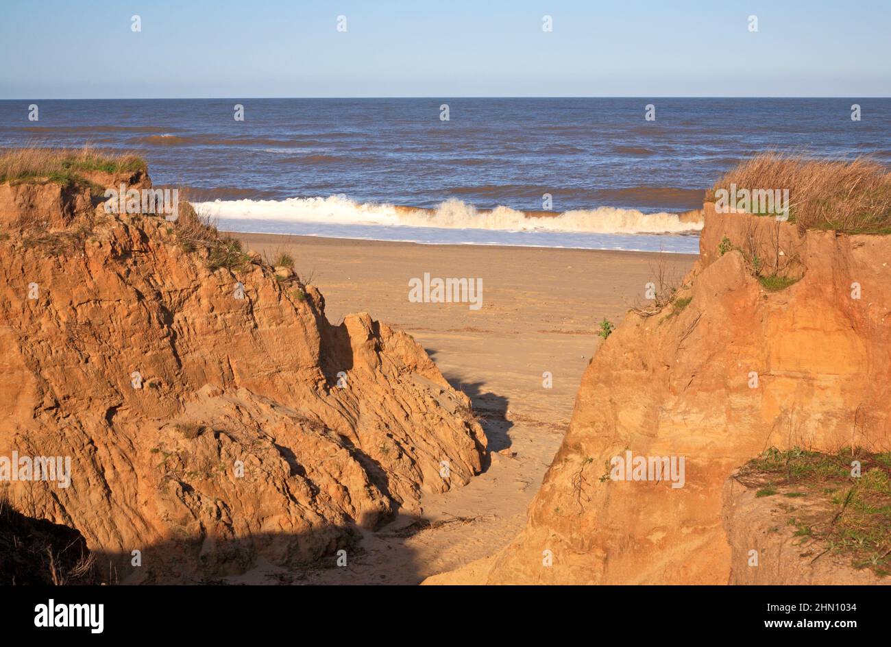Break in cliffs caused by run off of excess water from the land to the ...