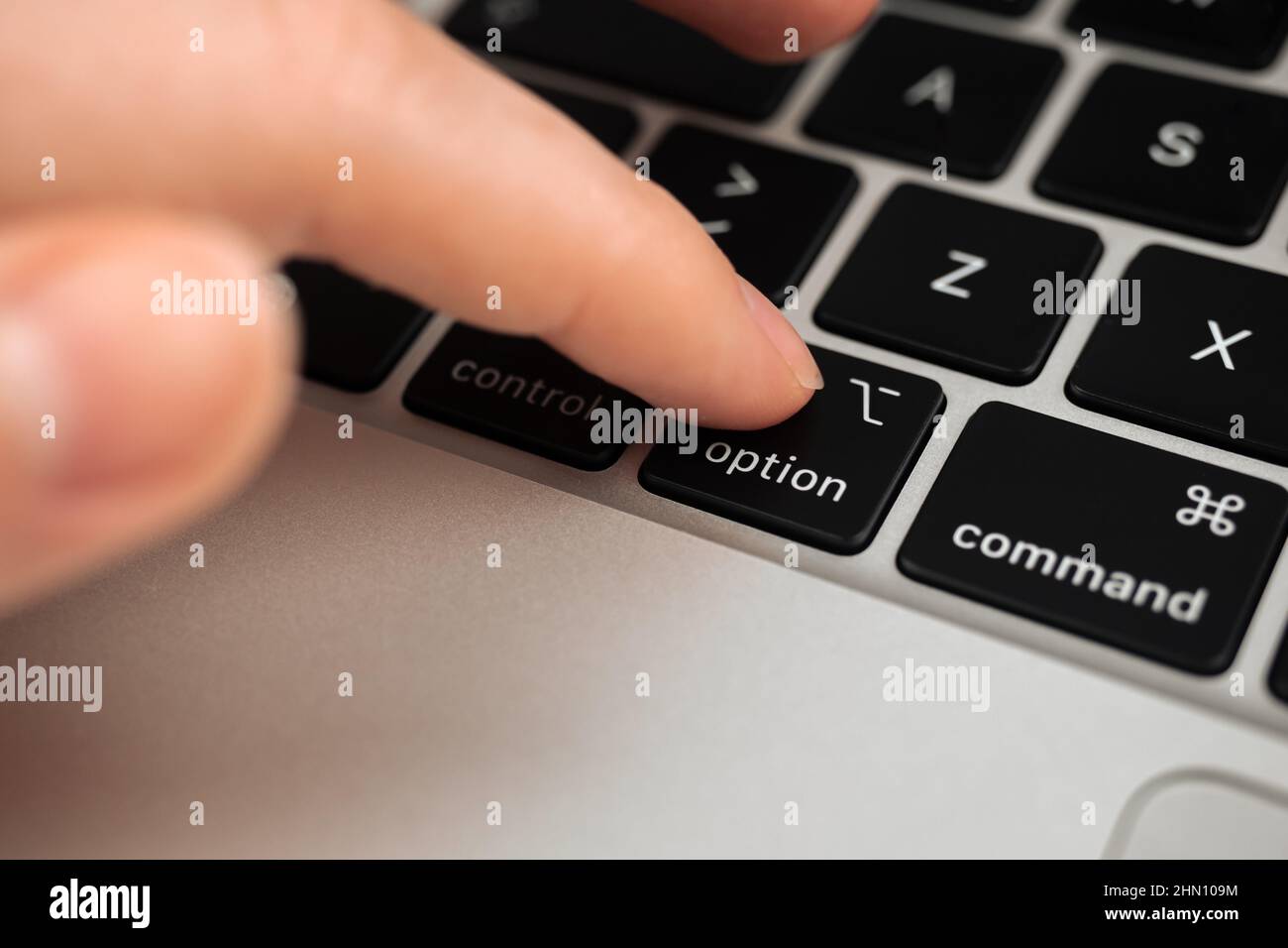 Hand pressing option key on modern laptop keyboard. Option sign and ...