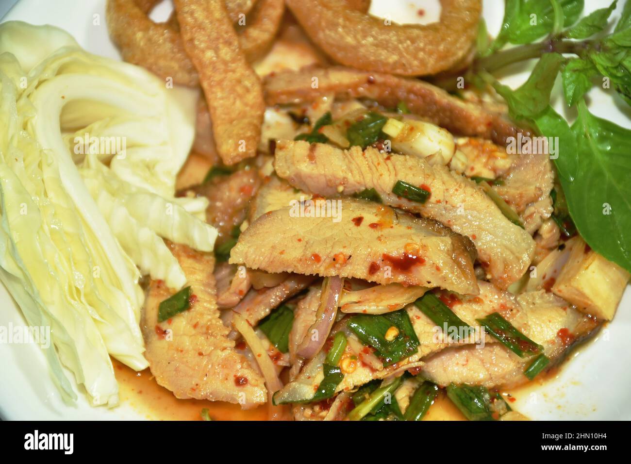 spicy roasted pork Thai salad eat with fresh basil leaf and cabbage on ...