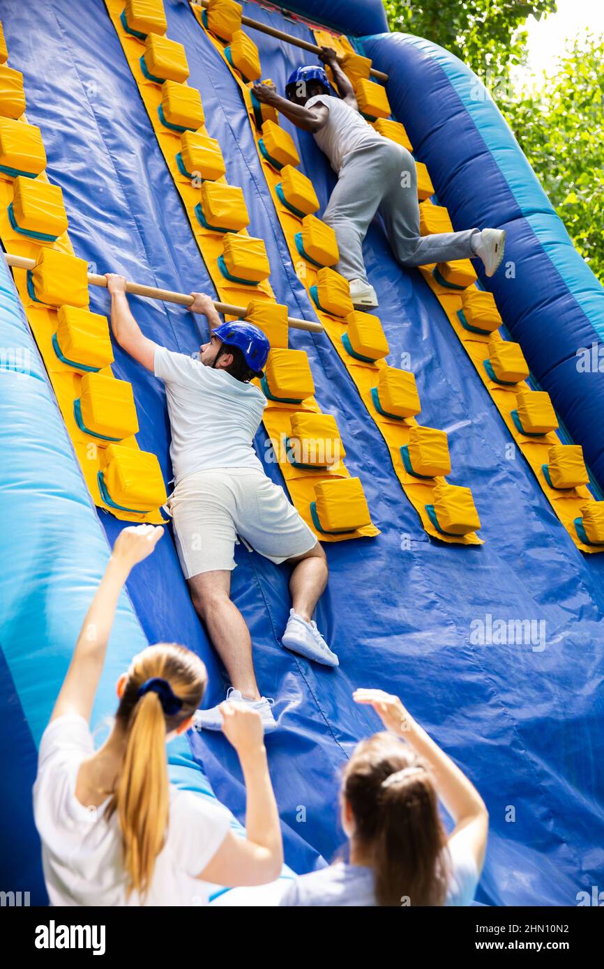 Inflatable slide Great race - climbing with a stick on an inflatable ...