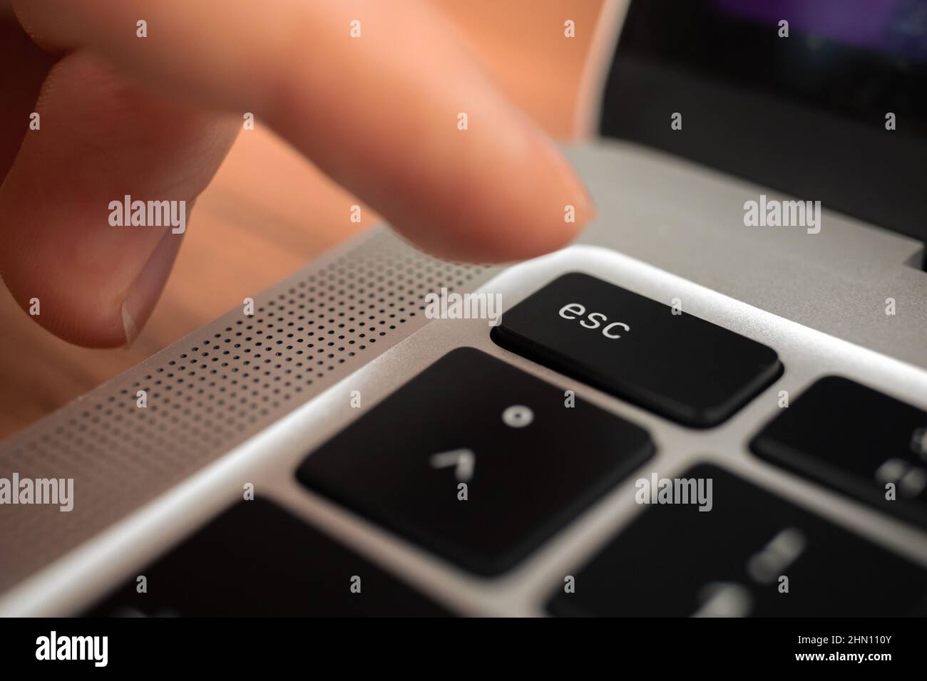 Hand pressing escape key on modern laptop keyboard. Esc sign and symbol ...