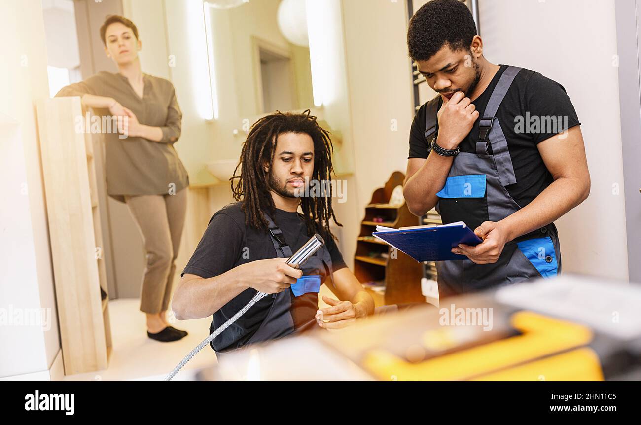 Customer watch craftsmen critically at work in the bathroom Room Stock ...