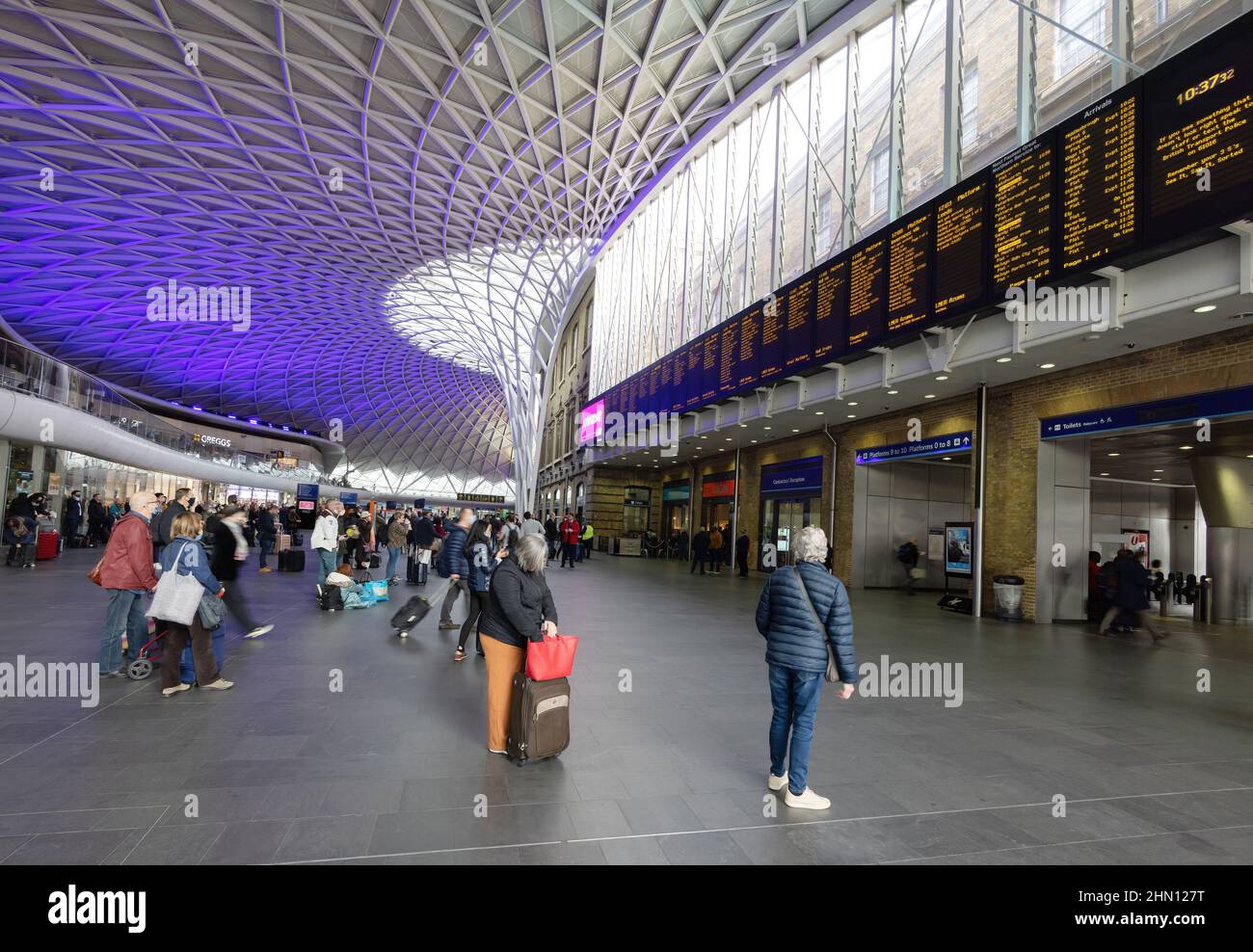 London Kings Cross Railway station concourse; passengers looking at the ...