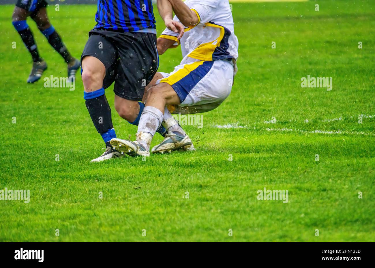 Soccer players tackling in the football pitch Stock Photo - Alamy