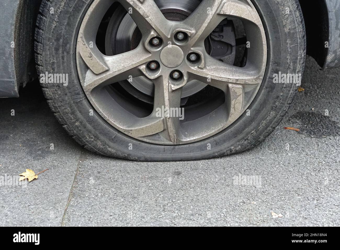 Flat tyre deflated pneumatic car tyre wheel Stock Photo - Alamy