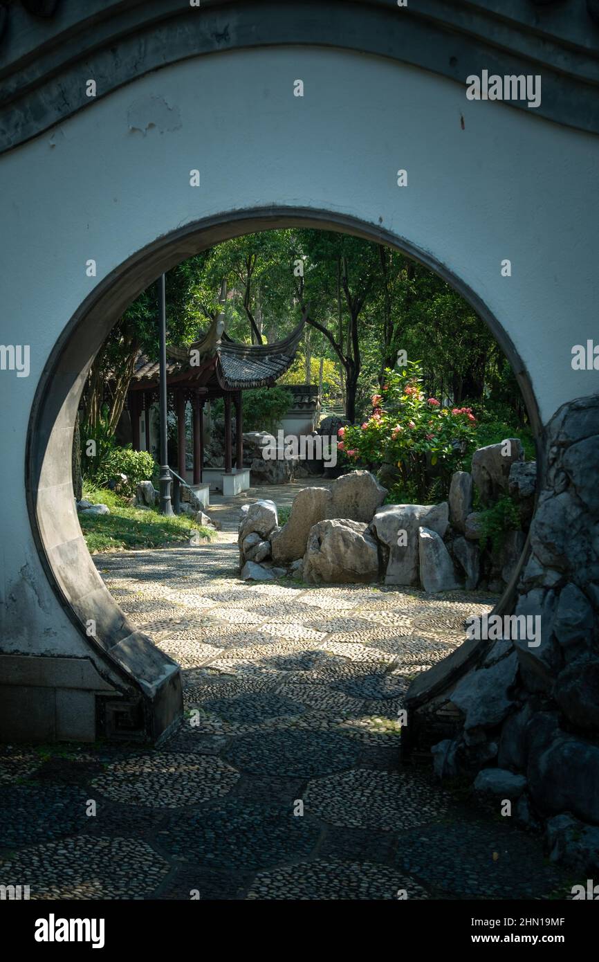 Traditional Chinese round door framing a Chinese pavilion in Kowloon ...
