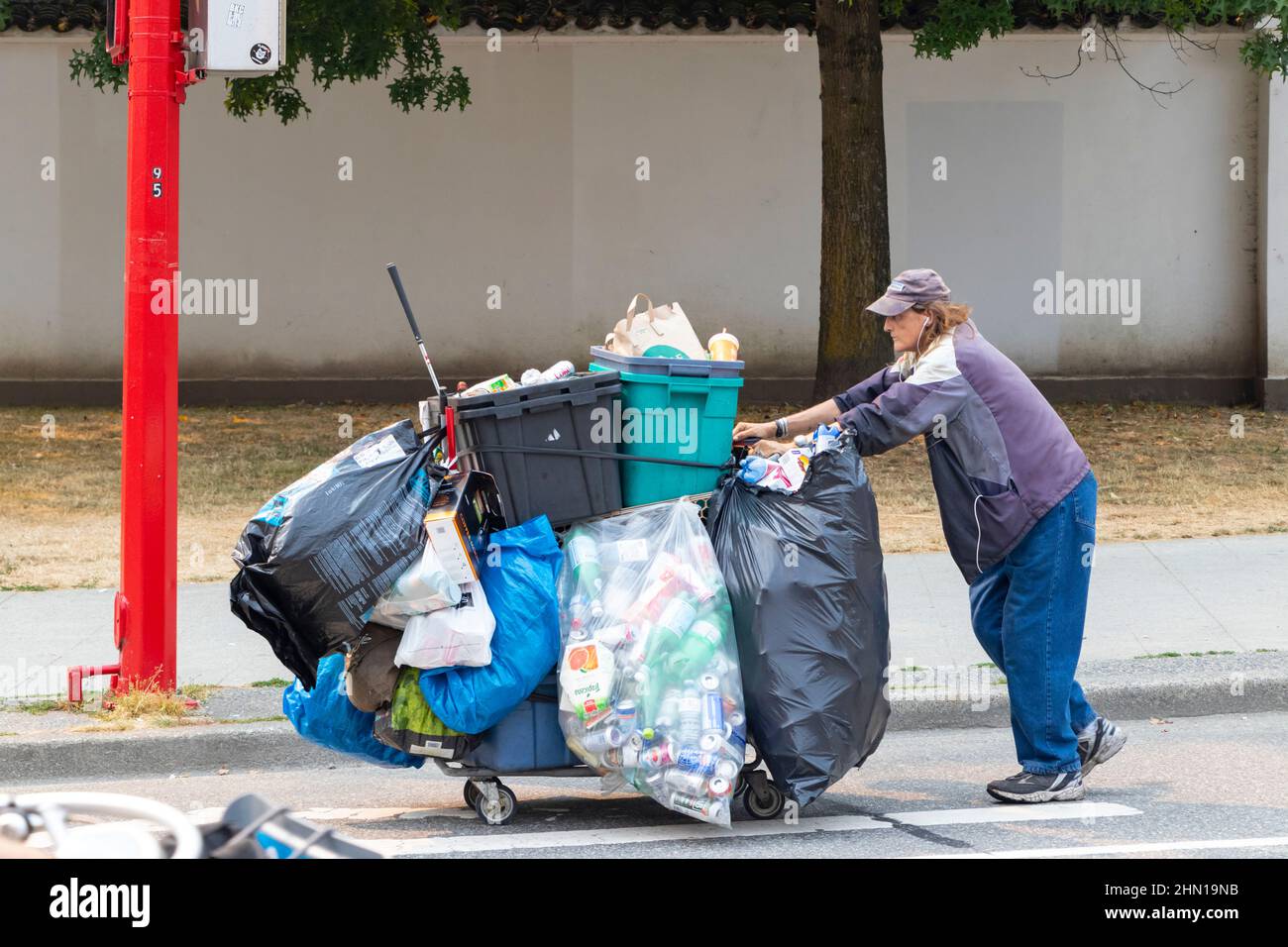 homeless man with shopping cart overloaded with his possessions in ...