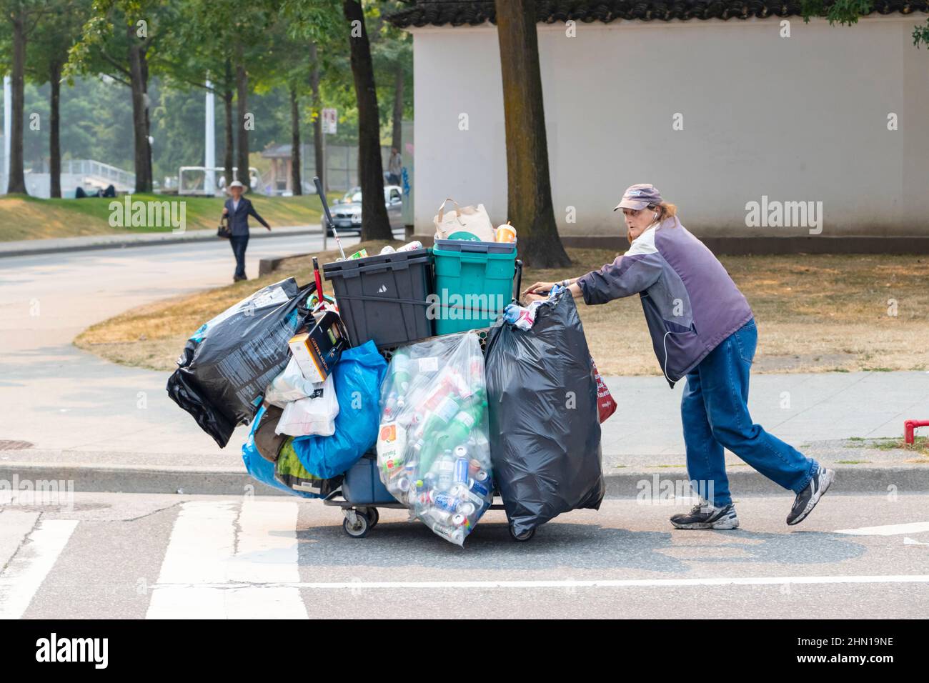 homeless man with shopping cart overloaded with his possessions in ...