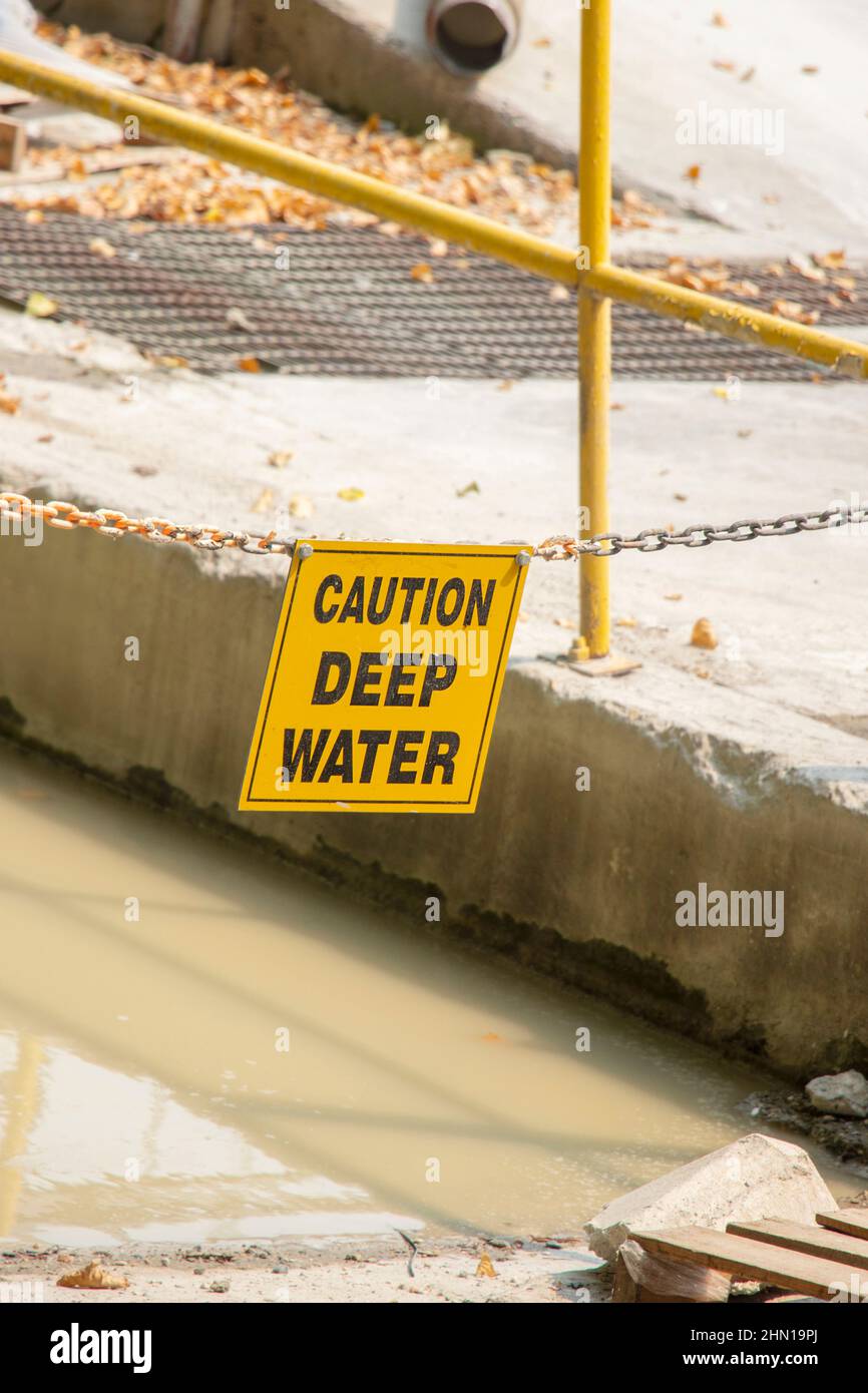 Yellow Caution Deep water warning sign hanging on chain on Granville ...