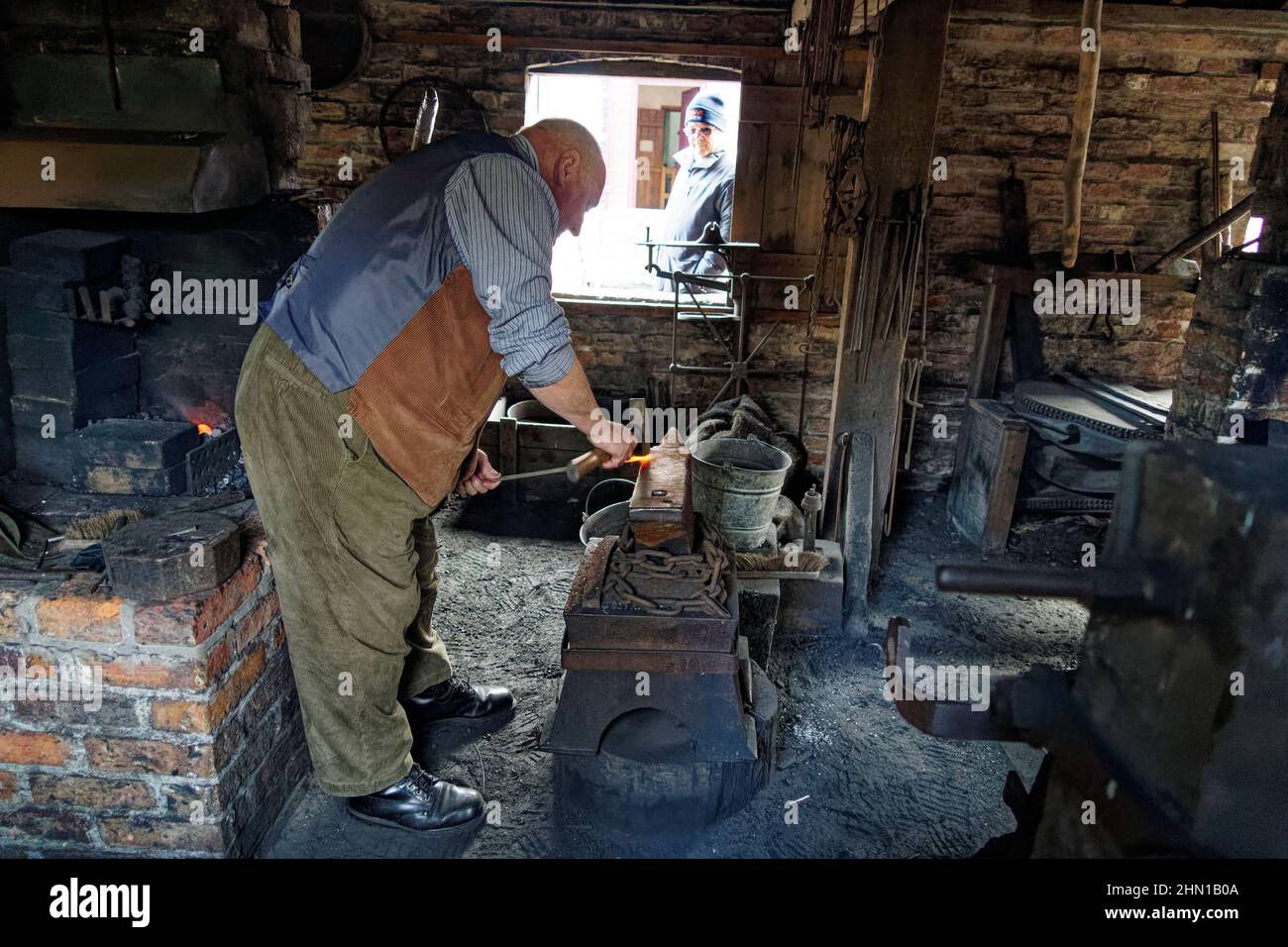 A Smith hammering hot metal on an anvil Stock Photo - Alamy