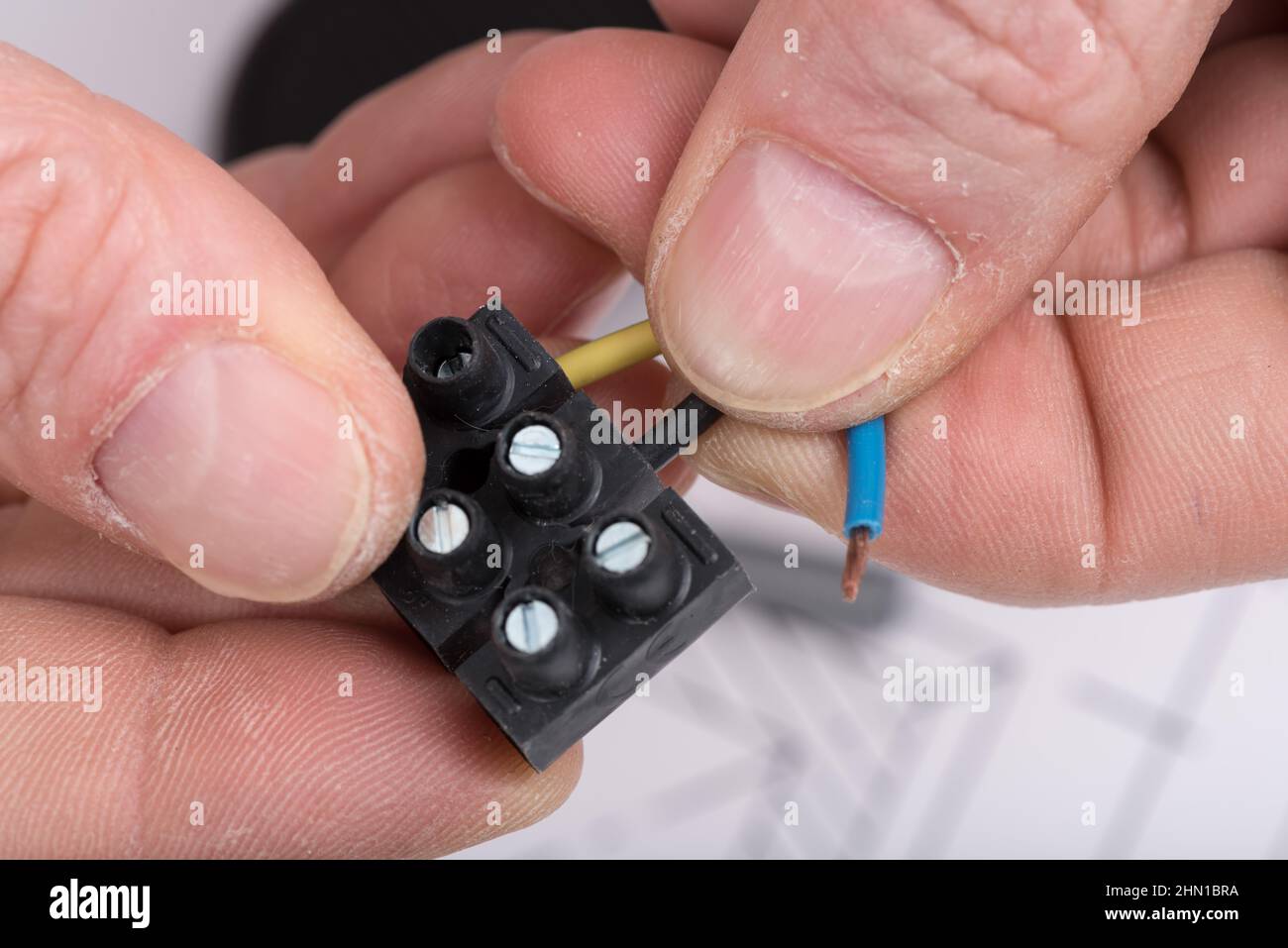 Hand putting a wire in a connector Stock Photo - Alamy