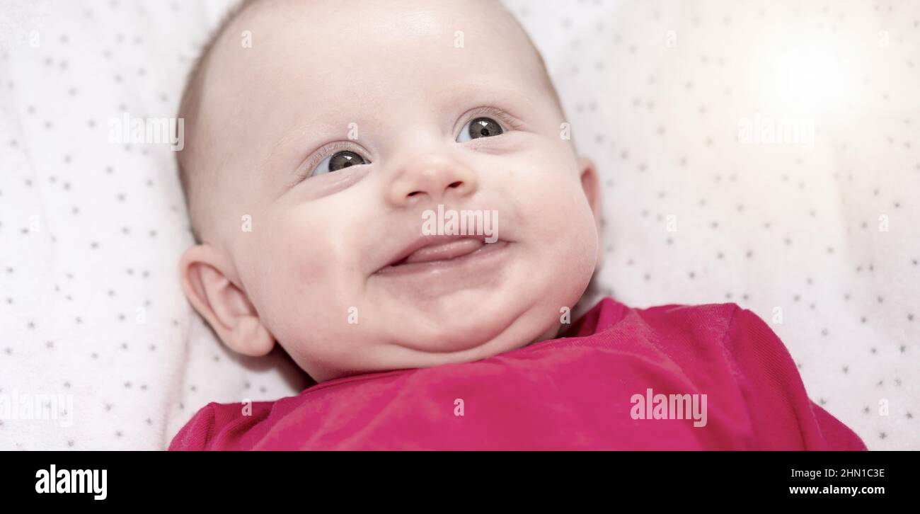 Portrait of smiling baby lying on back Stock Photo - Alamy
