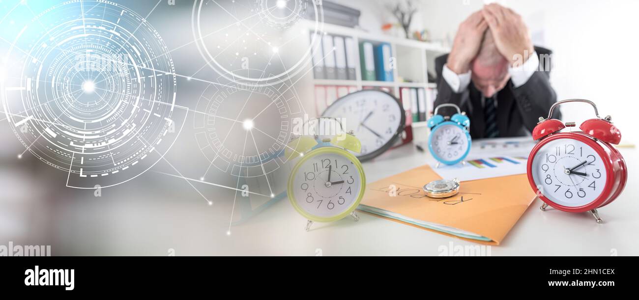 Stressed businessman behind his desk full of alarm clocks; panoramic ...