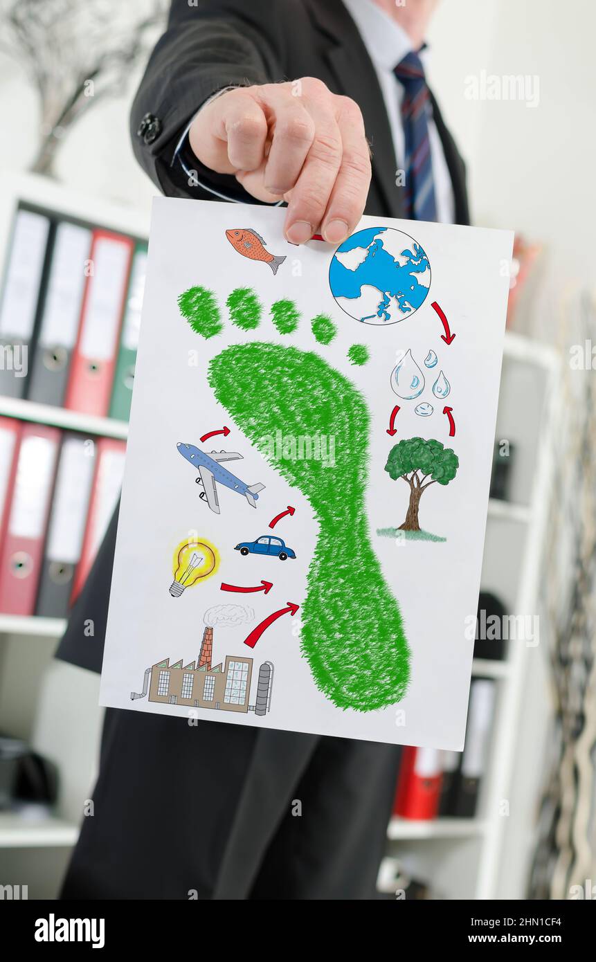 Paper showing carbon footprint concept held by a businessman Stock ...