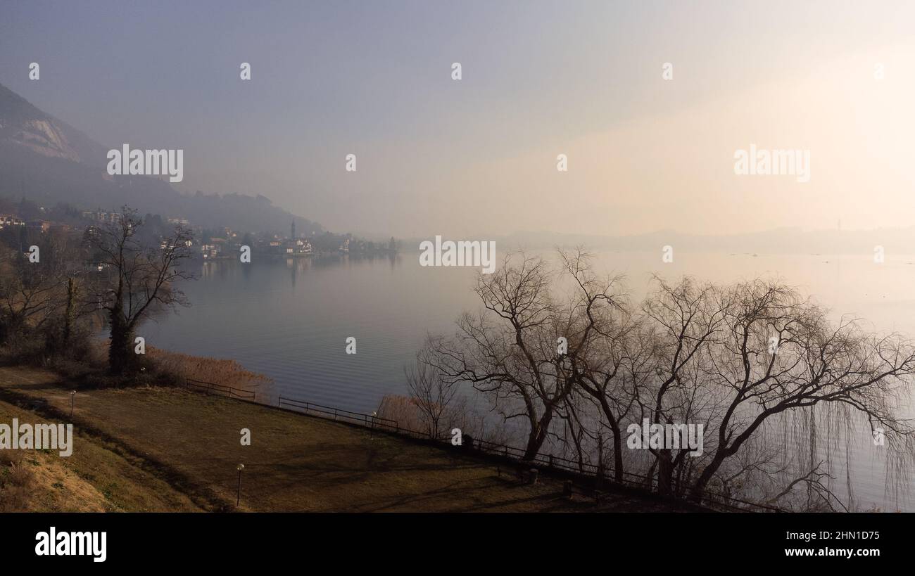Morning mist floating over the Lake with little village in the ...