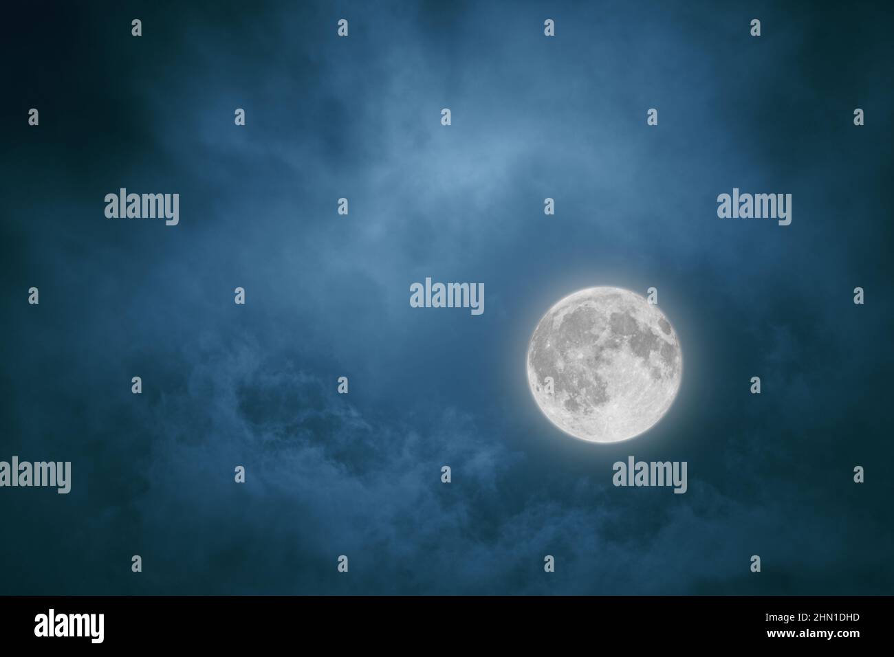 Full moon in the night sky shining through the clouds Stock Photo - Alamy
