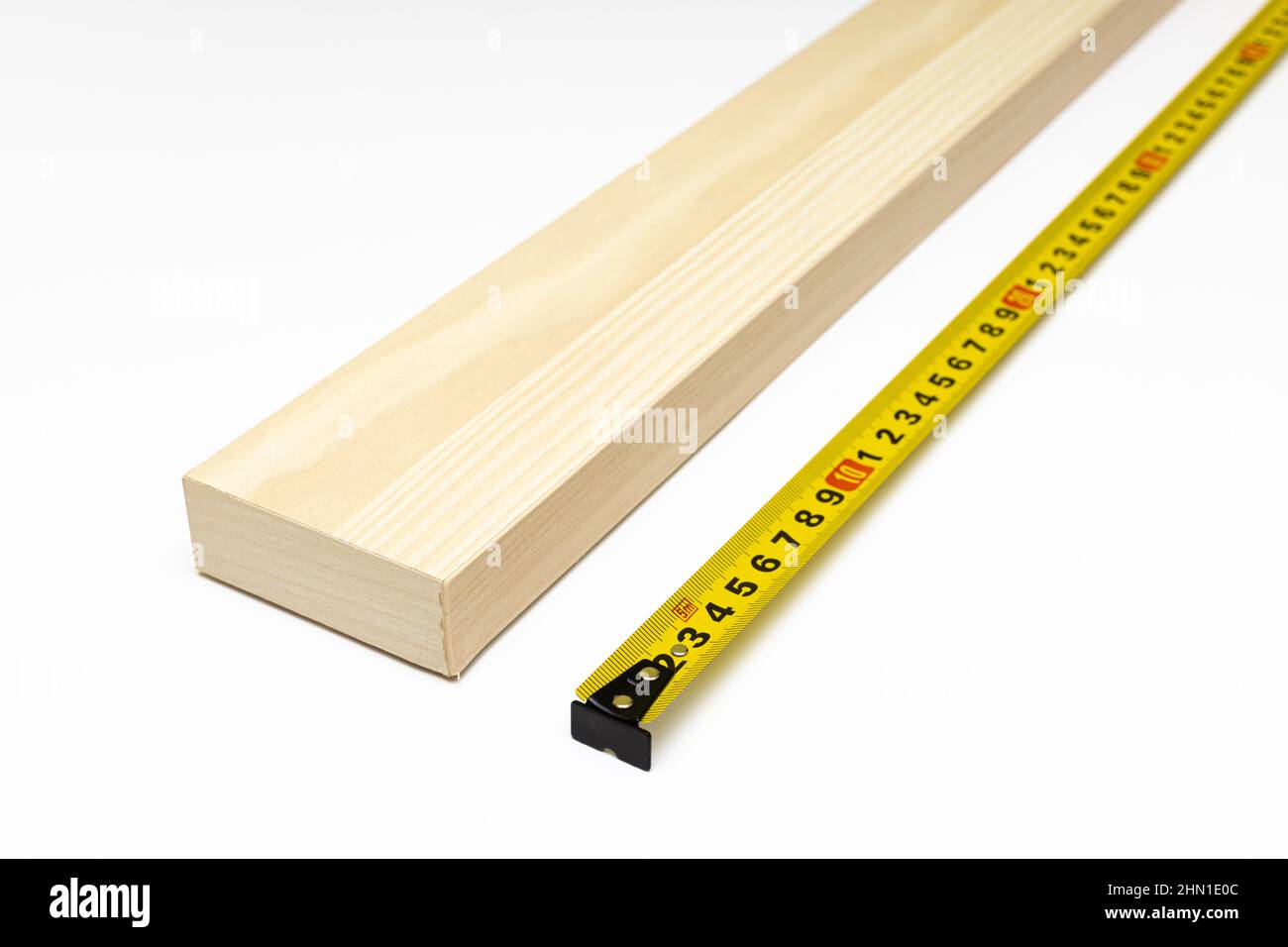 an open tape measure lies next to a wooden beam. High quality photo ...