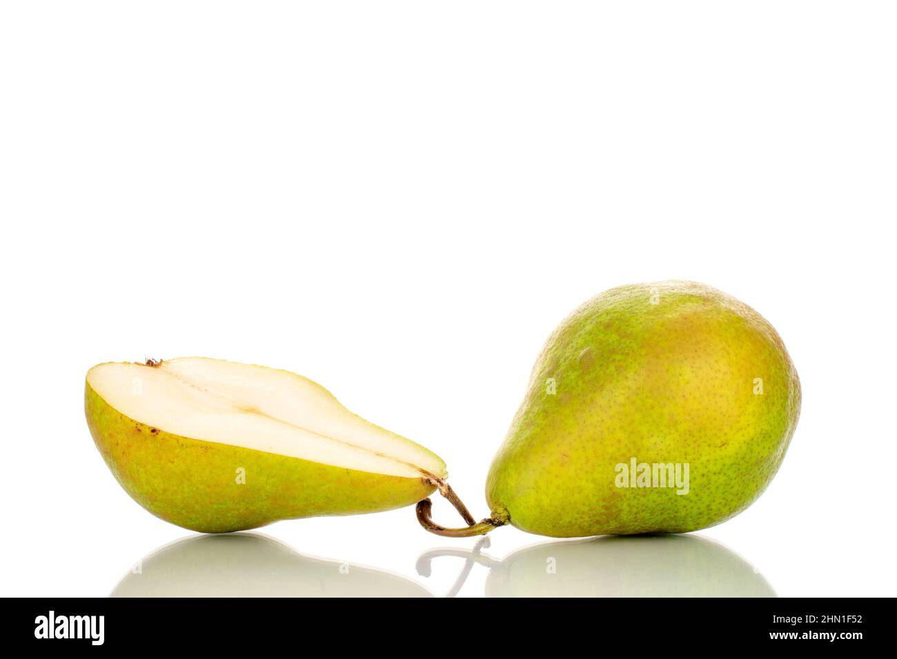 One half organic sweet pear and one whole pear, macro, isolated on ...