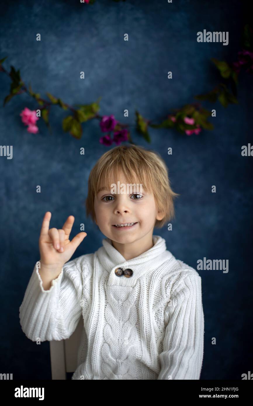 Cute little toddler boy, showing I LOVE YOU gesture in sign language on ...