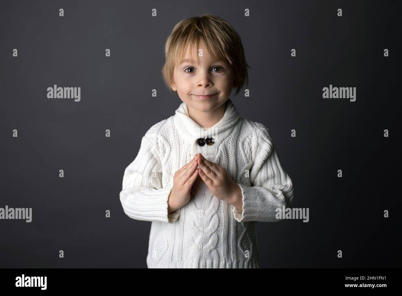 Cute little toddler boy, showing home gesture in sign language on gray ...