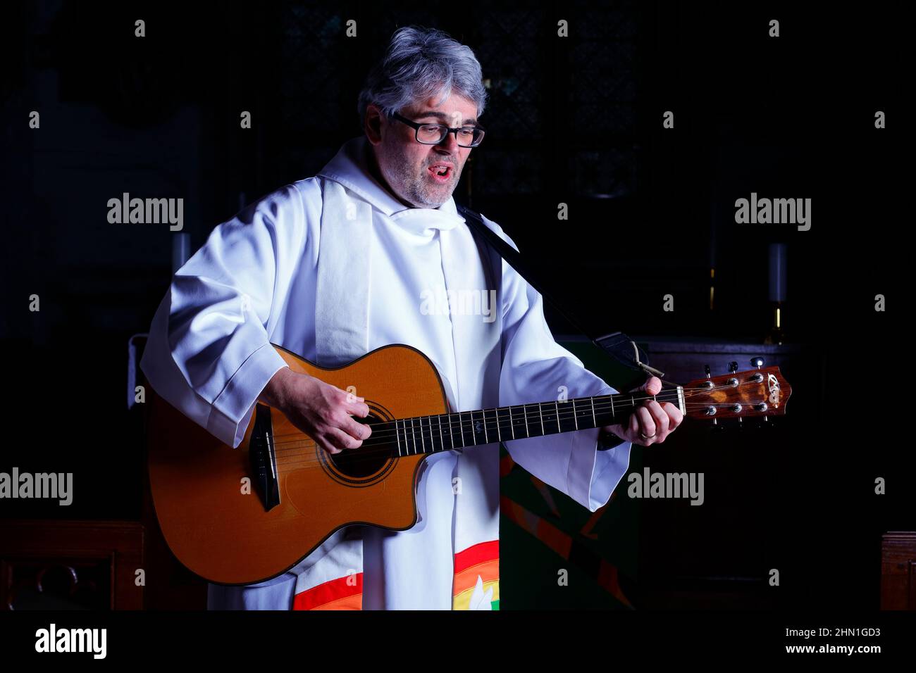 Reverend Bob Bailey playing guitar during one of his church services ...